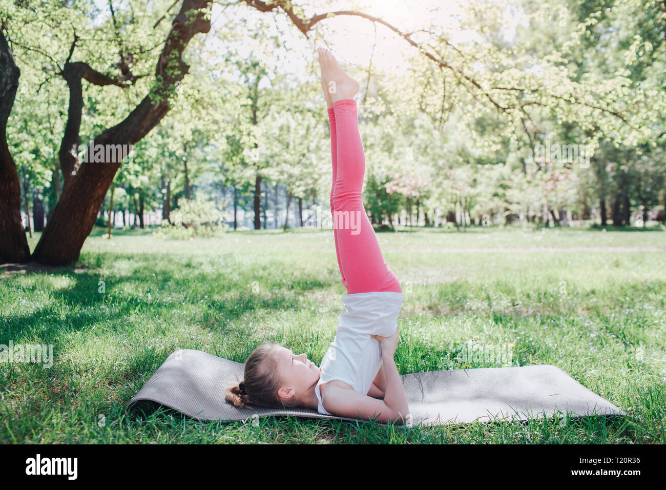 Girl Is Holding Her Legs Up In The Air And Balancing She Is Supporting Her Hips With Hands