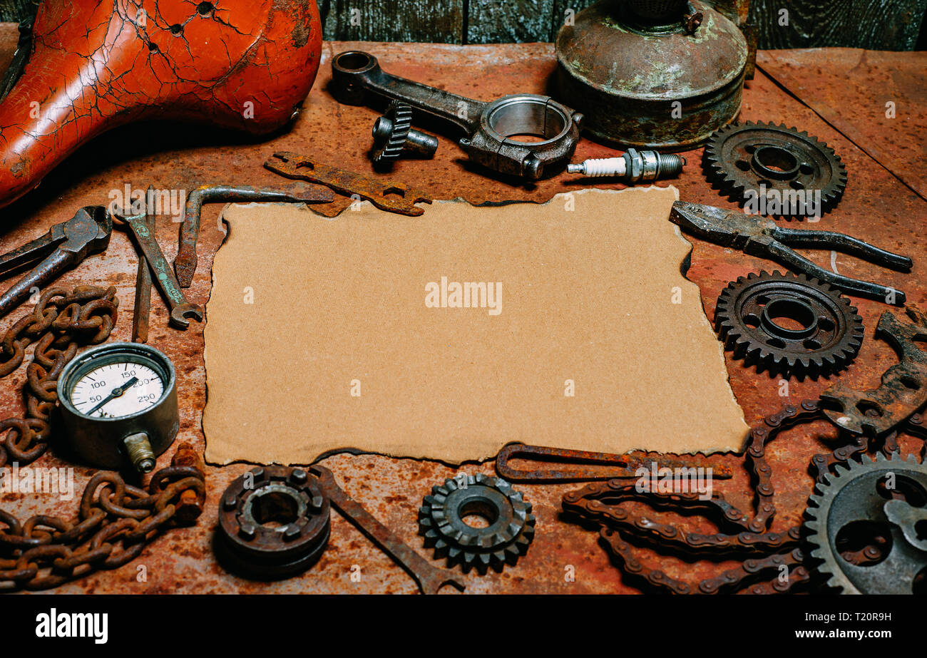 Vintage paper in the center of rusty chain, tools on old metal ...