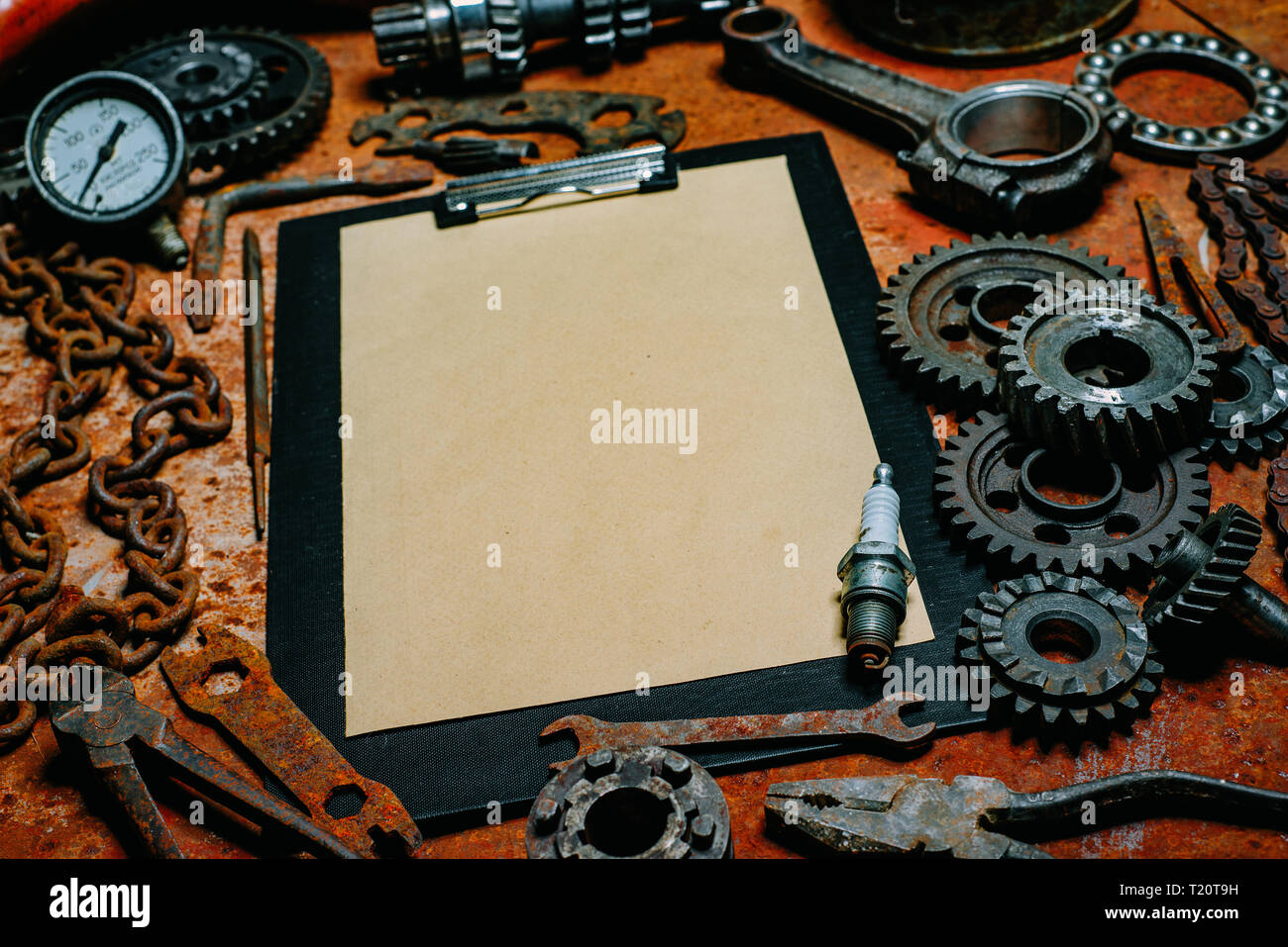Clipboard with paper in the center of rusty tools, gears on old metal ...