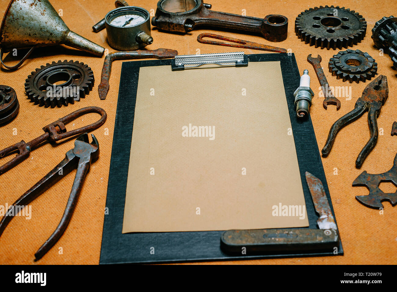 Closeup clipboard with paper for your info in the center of rusty tools ...