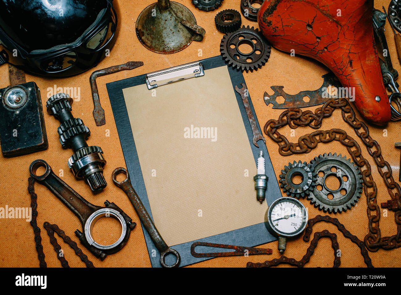 Clipboard with paper for your information in the center of rusty tools ...