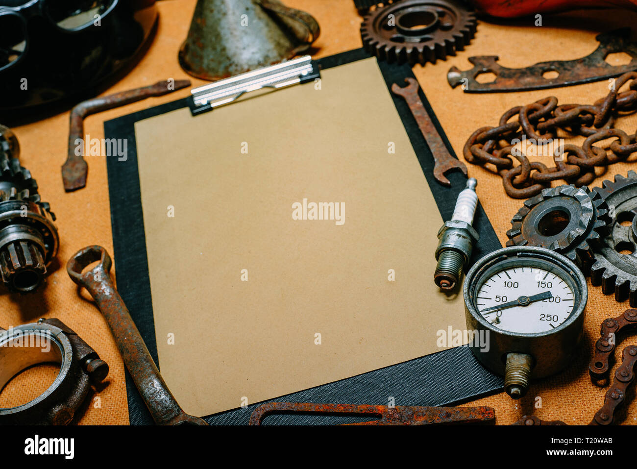 Closeup clipboard with paper for your info in the center of rusty tools ...