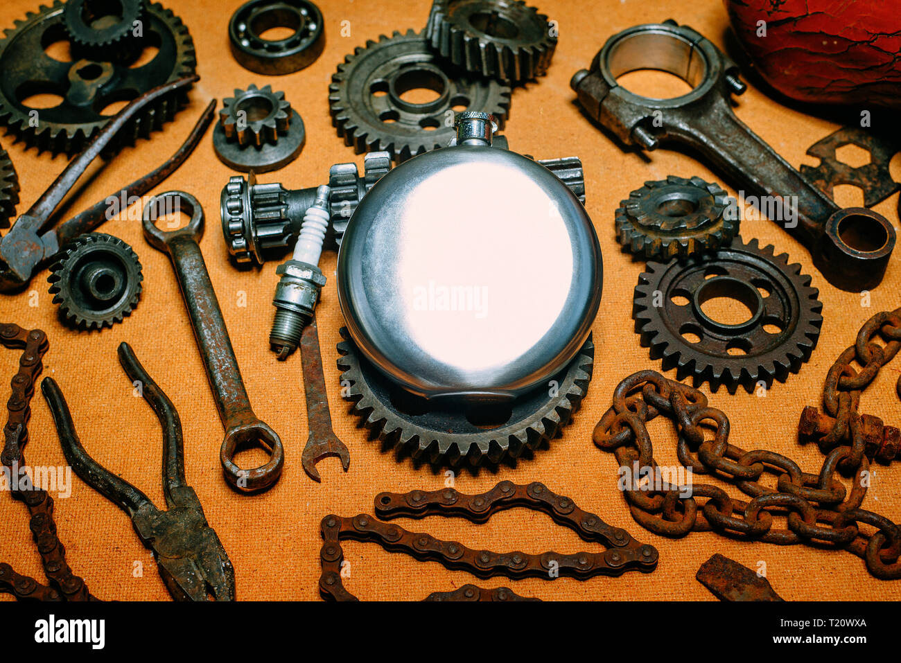 Round steel flask in the center of rusty tools, gears on vintage ...