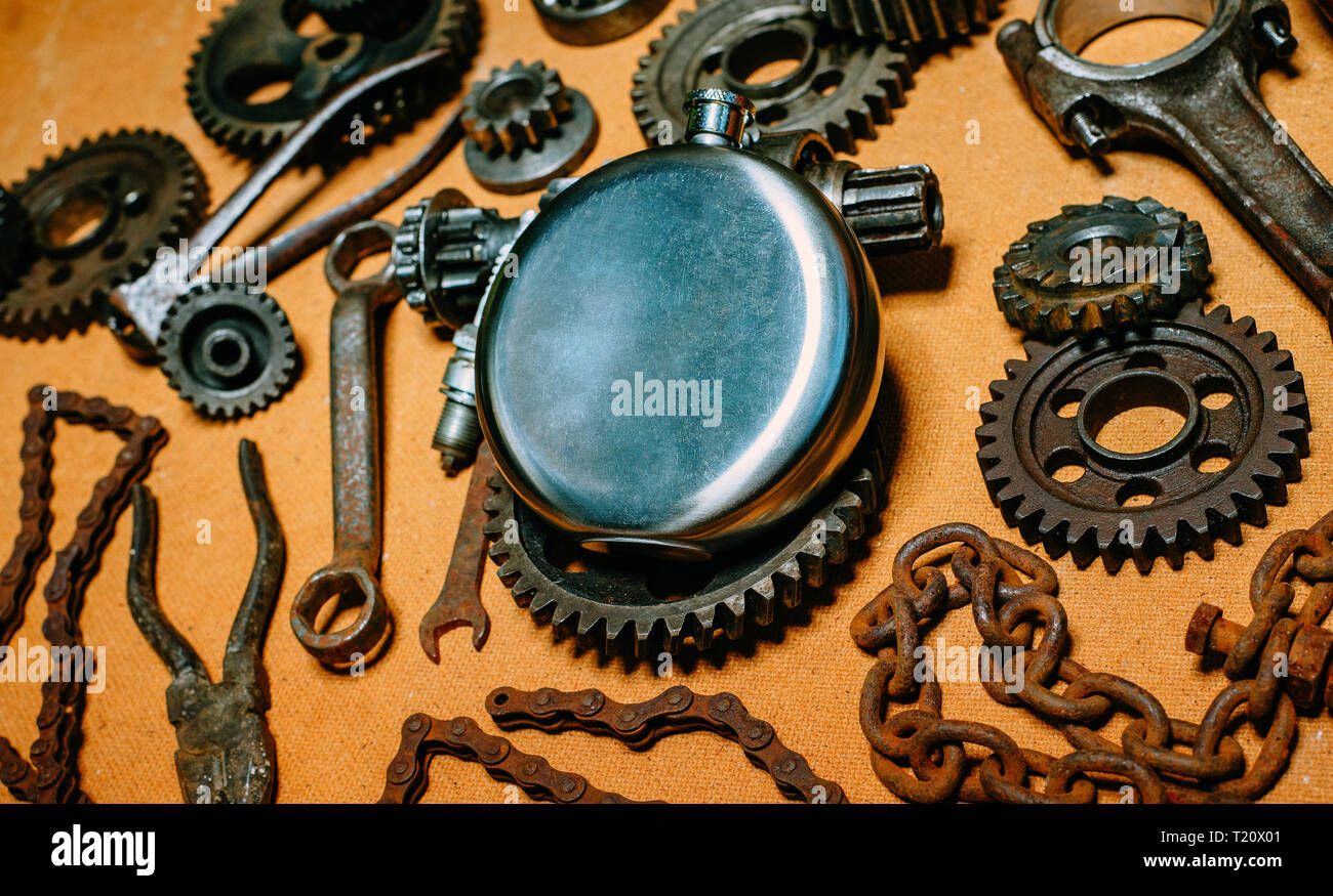 Round steel flask in the center of rusty tools, gears on vintage ...