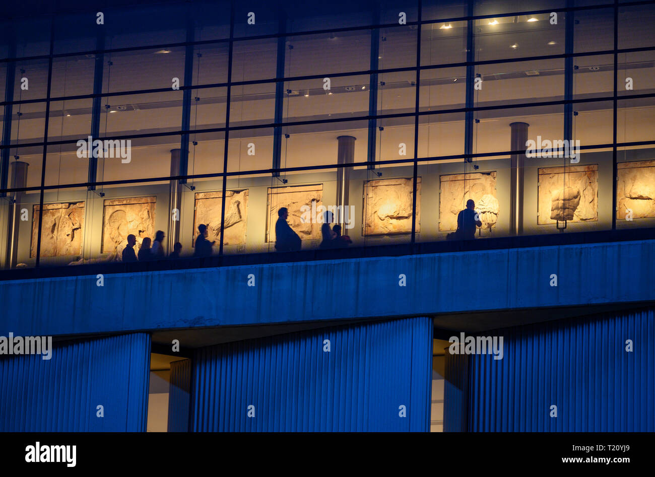 Visitors looking at the Parthenon marbles, seen through the windows of ...