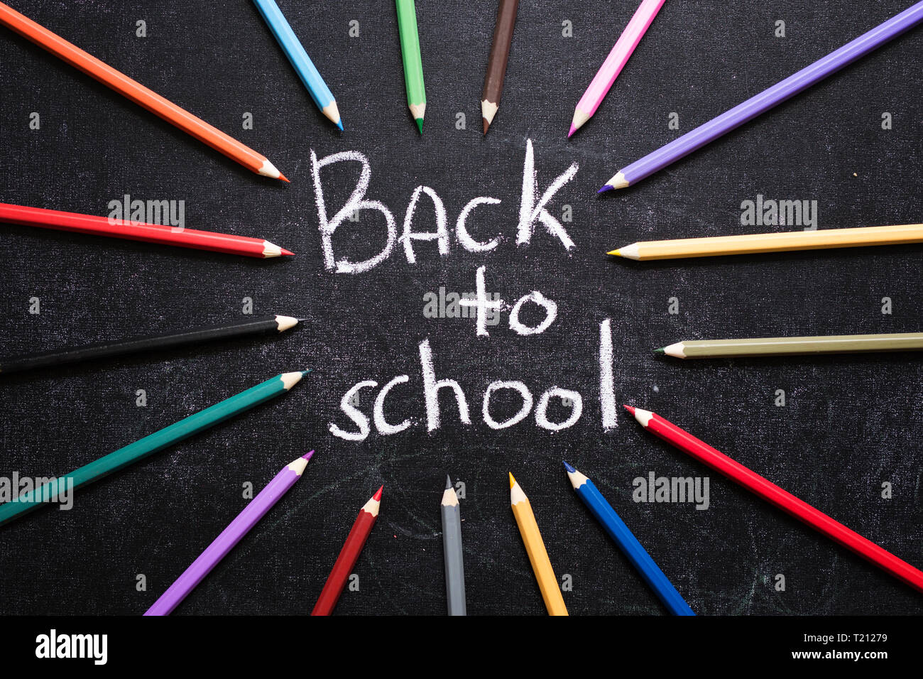 Coloured pencils around Back to School words on slate black background ...