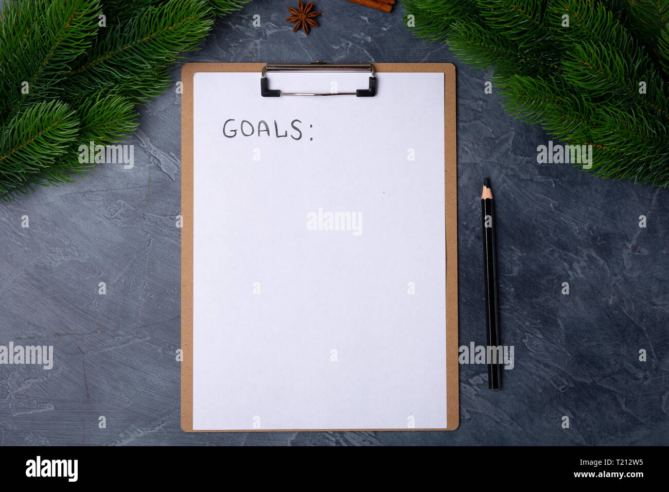 Blank paper with goals title and black pencil on grey table. Flat lay ...
