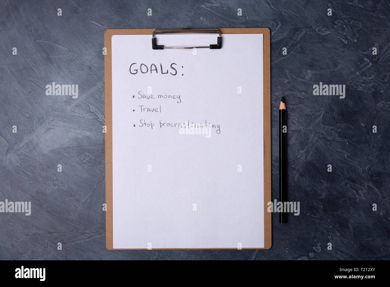 Paper with list of goals and black pencil on grey table. Flat lay. Top ...