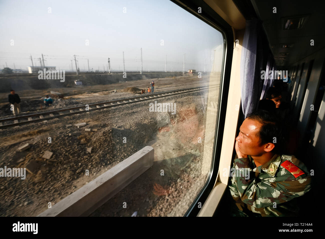 Chinese soldier looking out of train window at passing scenery Stock ...