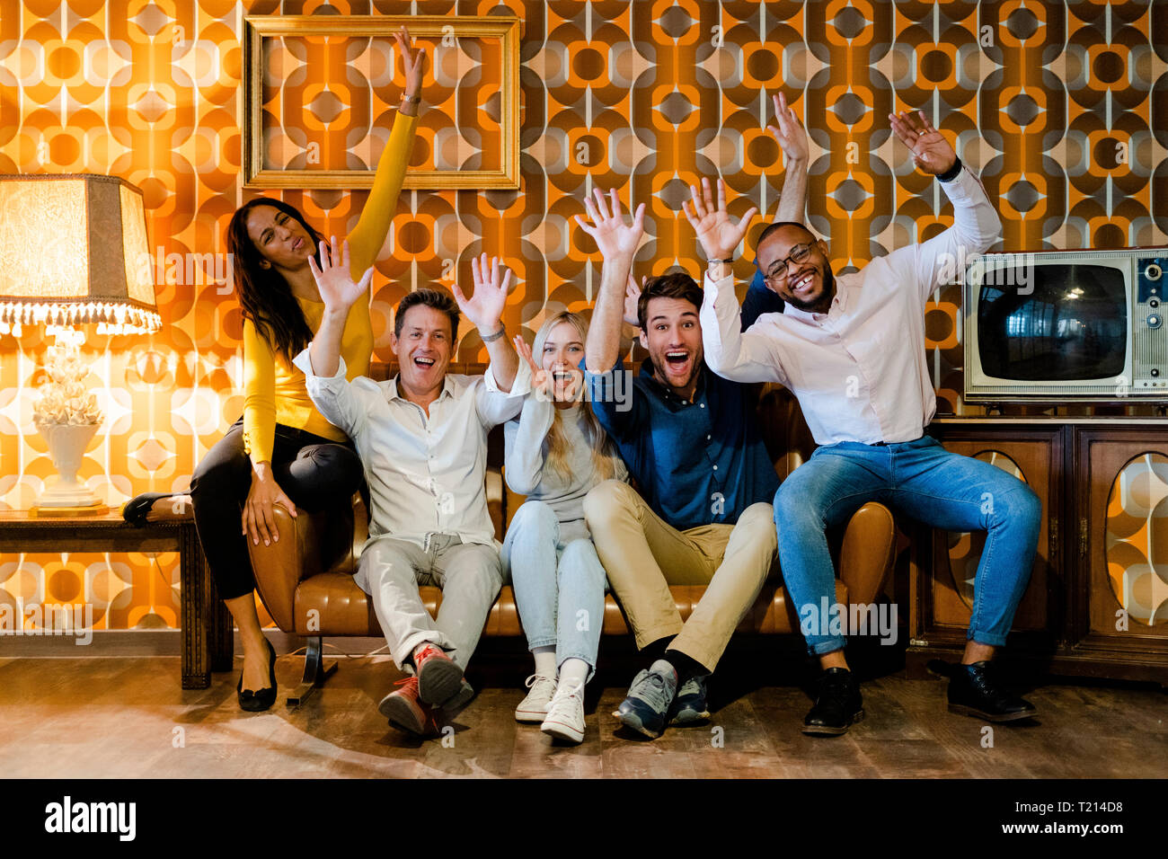Group of happy people sitting on couch in vintage living room Stock ...