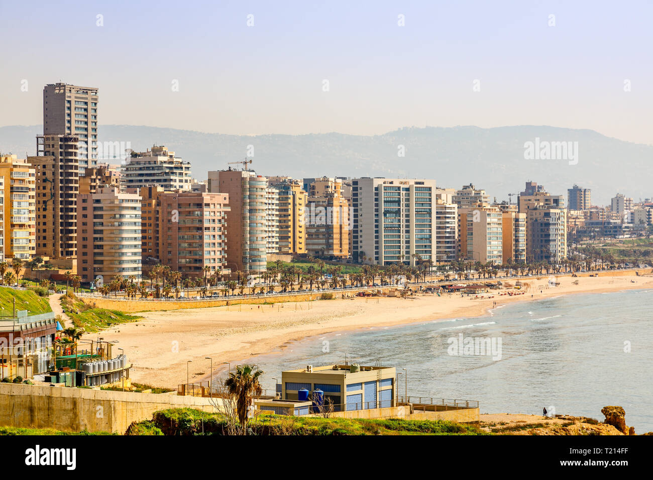 Downtown buildings and towers with road, sandy beach and sea in the ...