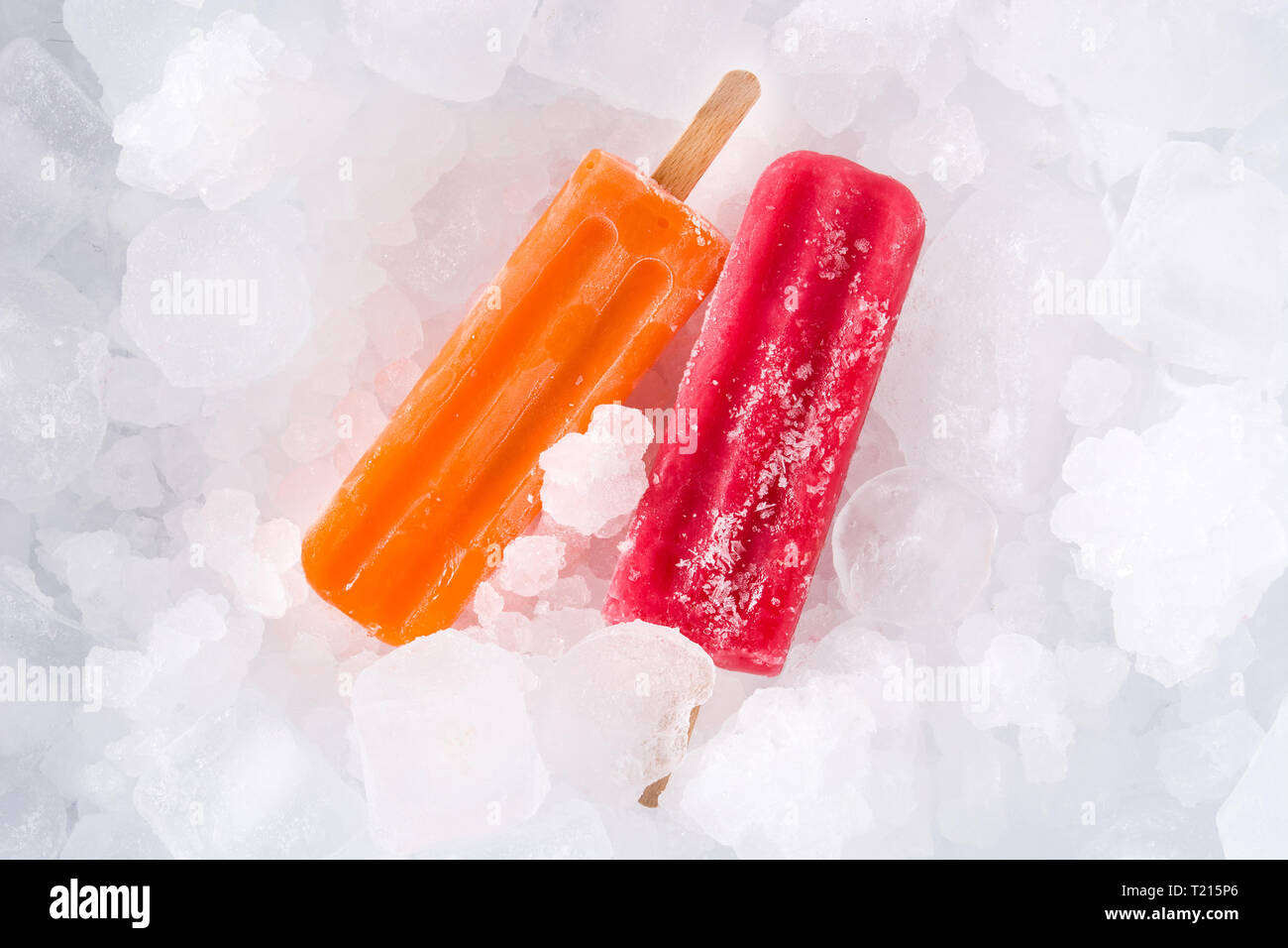 Orange and strawberry popsicles on ice cubes. Top view Stock Photo - Alamy