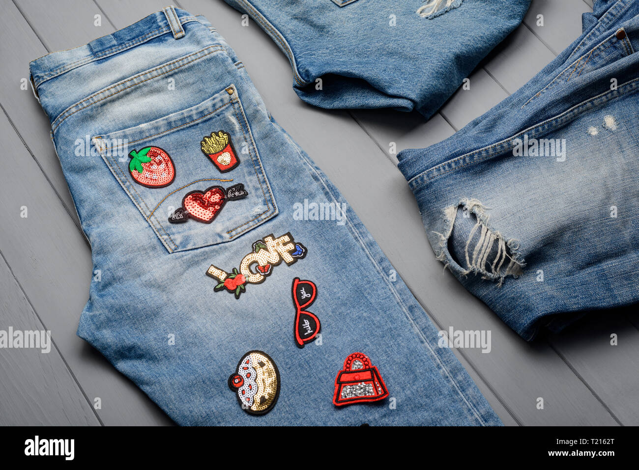 Jeans with various patches Stock Photo - Alamy