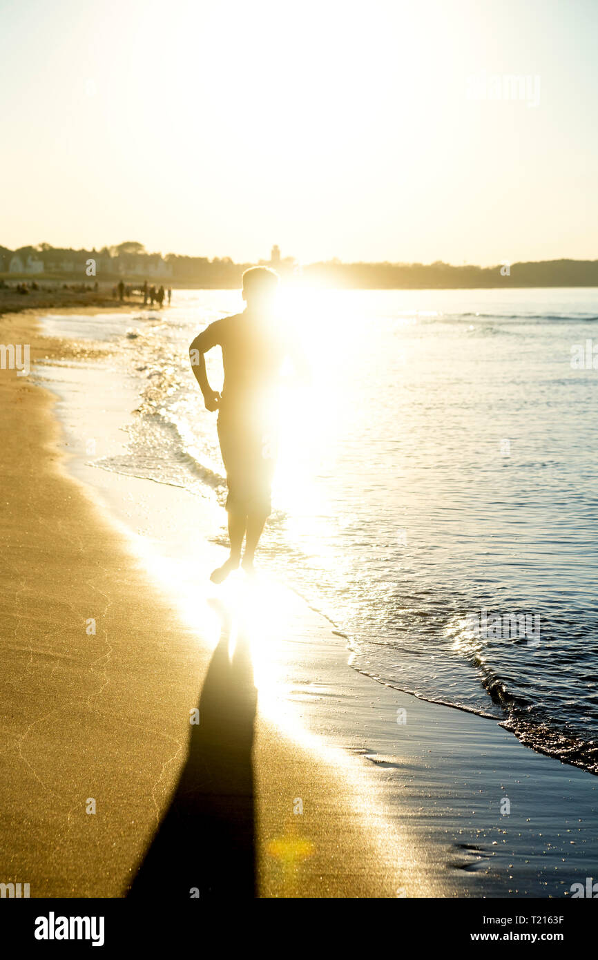 Man jogging at the beach at sunset Stock Photo - Alamy