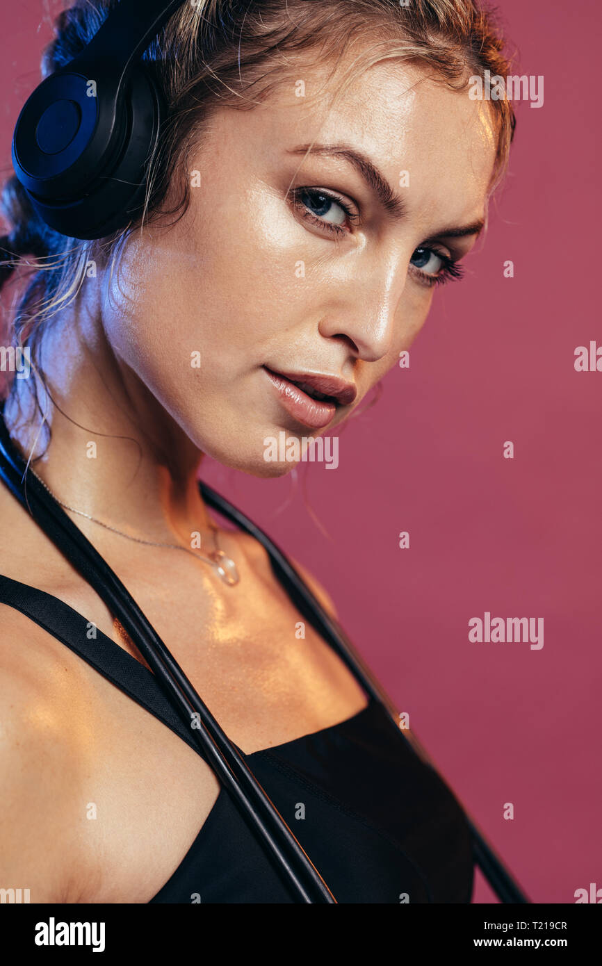 Close up of fit young woman wearing headphones with skipping ropes ...