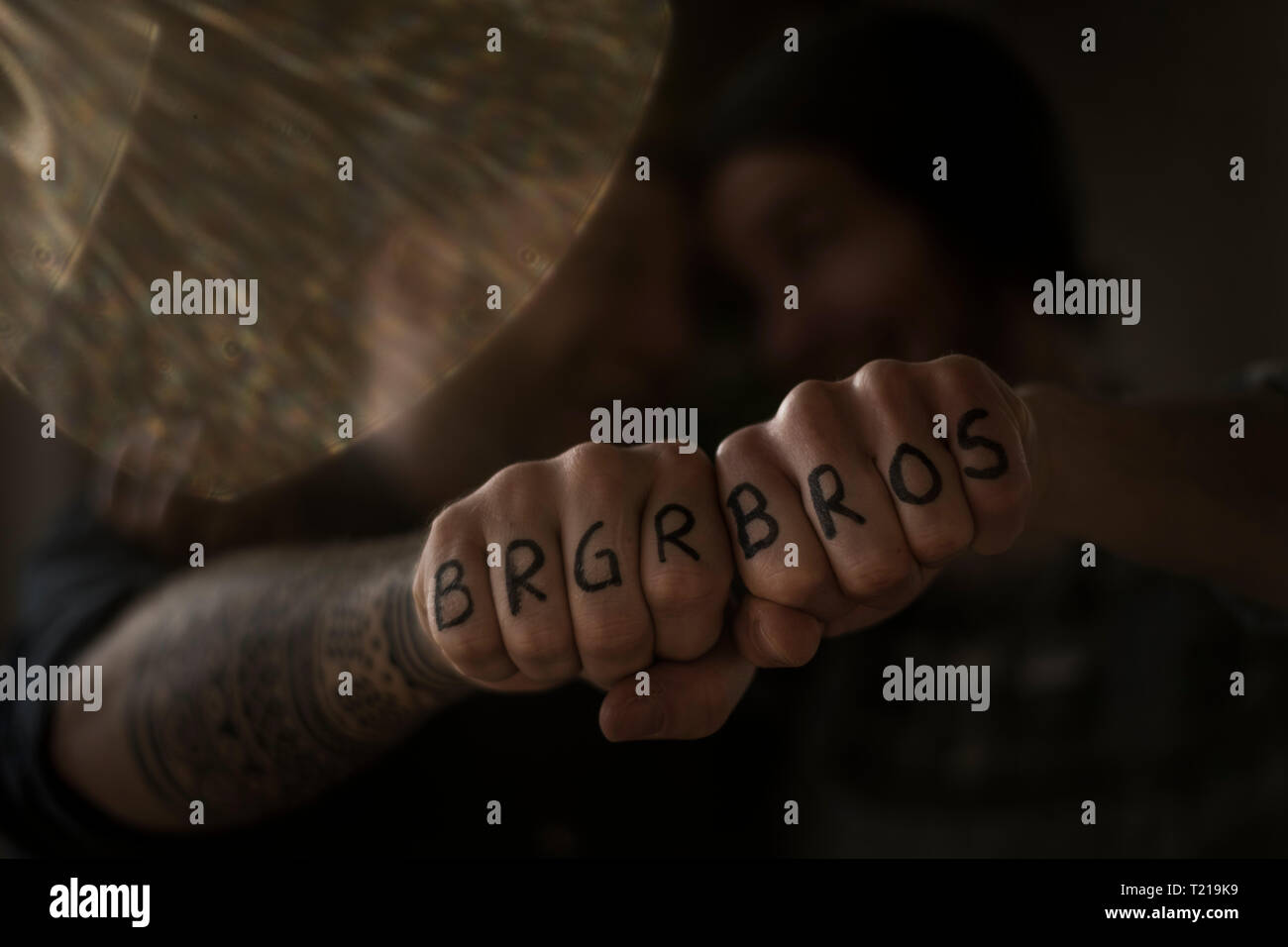 Friends holding fists together, showing their tattoos Stock Photo - Alamy