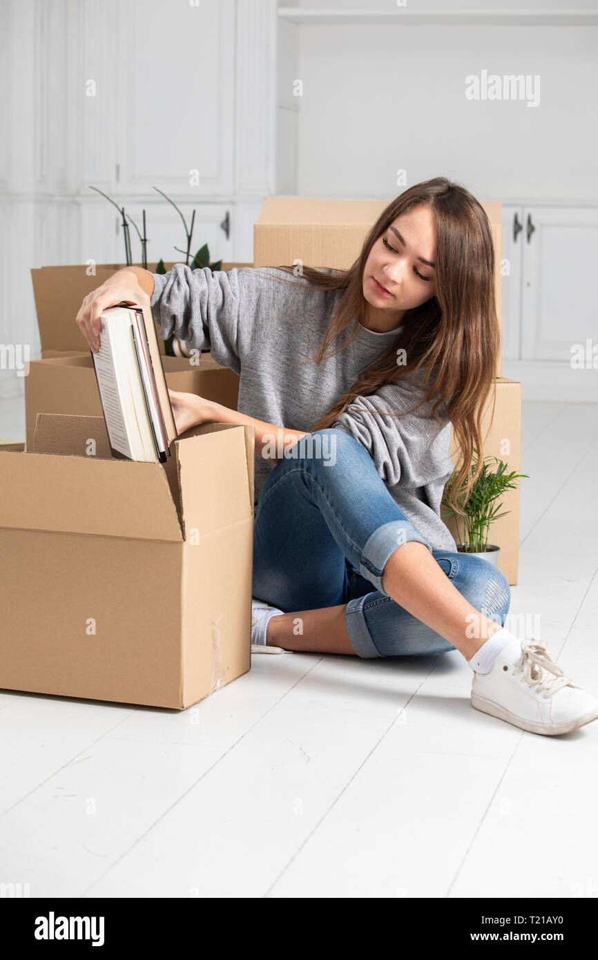 Woman sitting on the floor packing cardboard boxes Stock Photo - Alamy