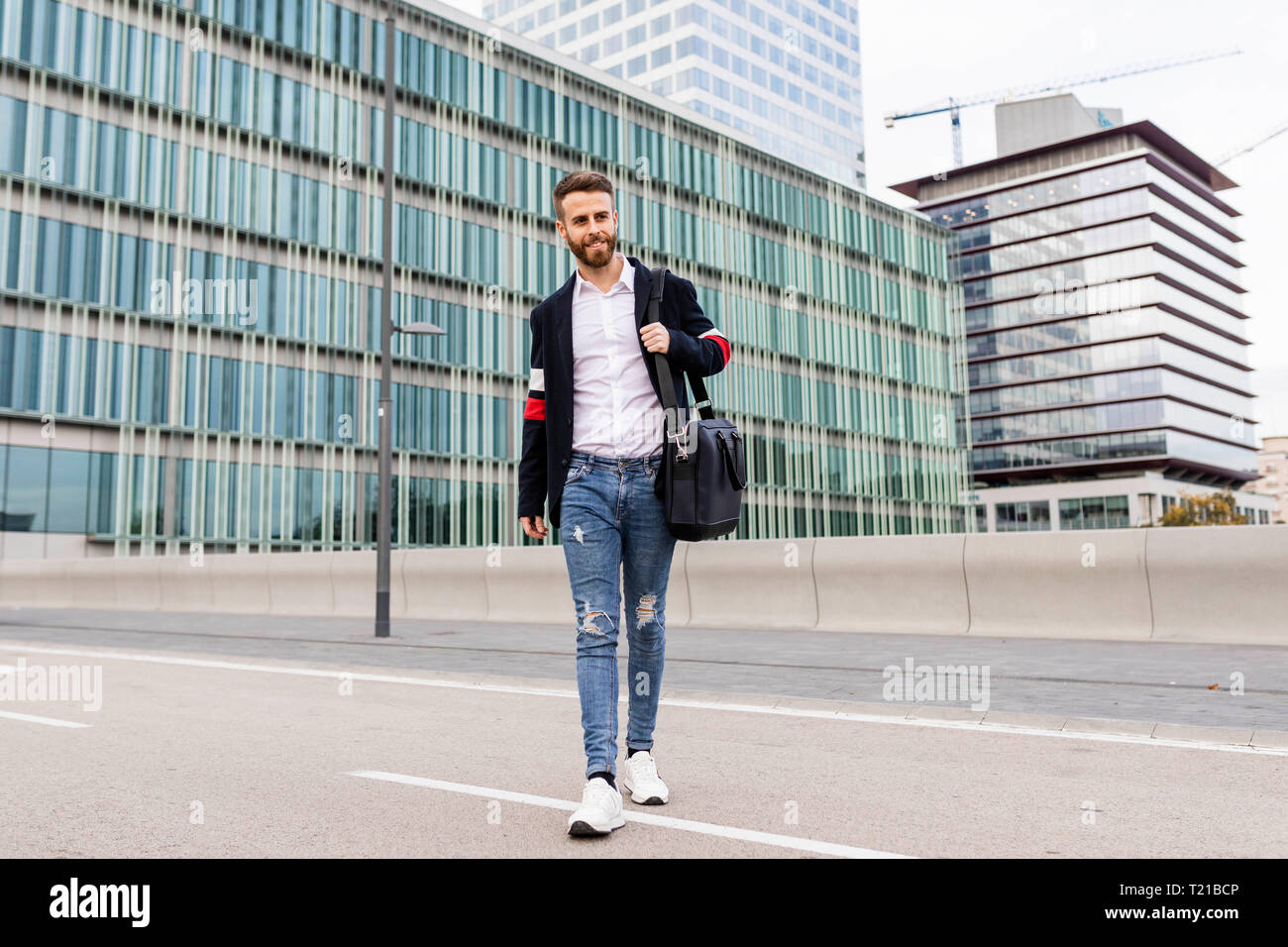 Stylish businessman walking in the city crossing a street Stock Photo ...