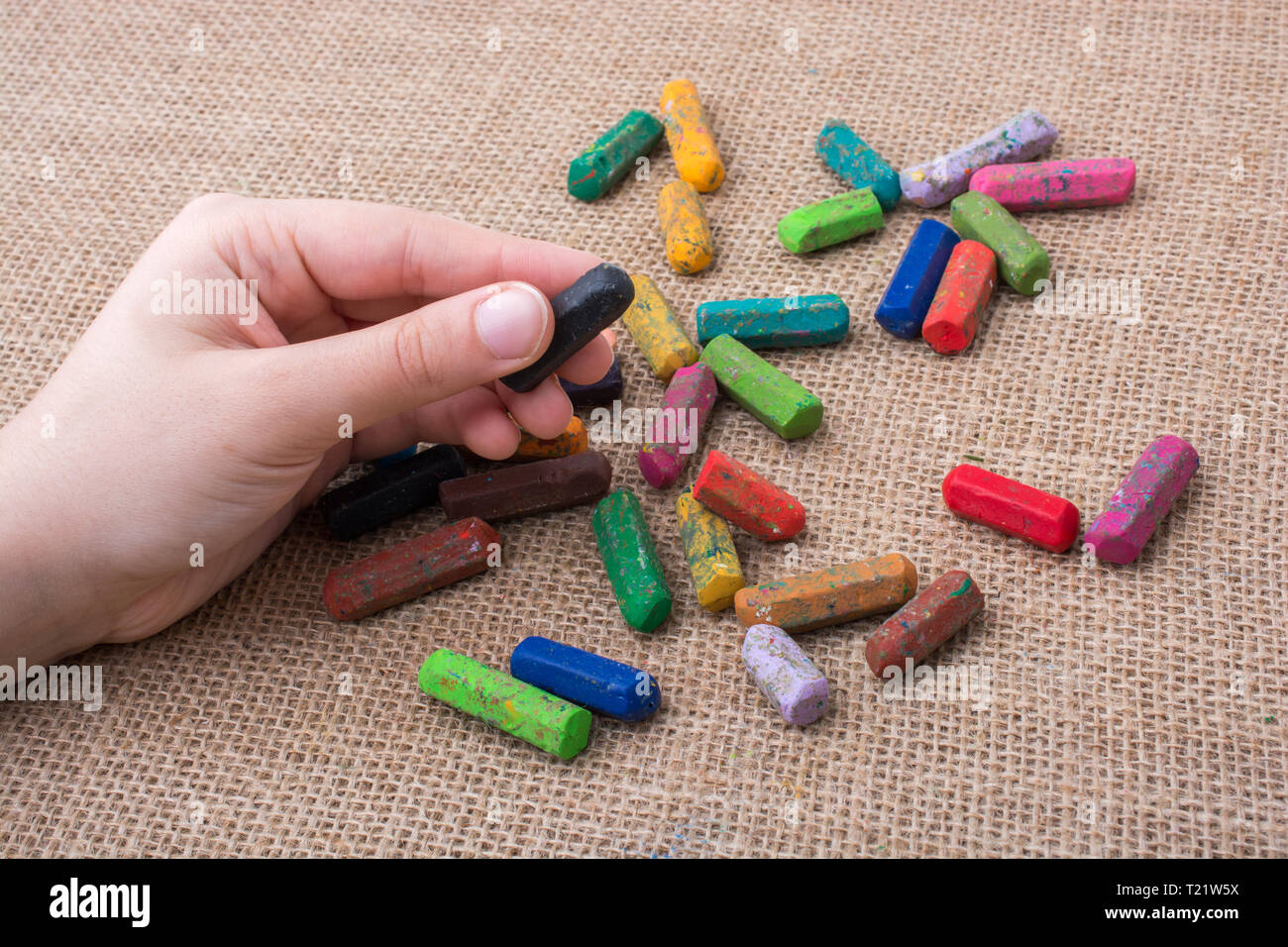 Used color crayons and a hand holding one Stock Photo - Alamy