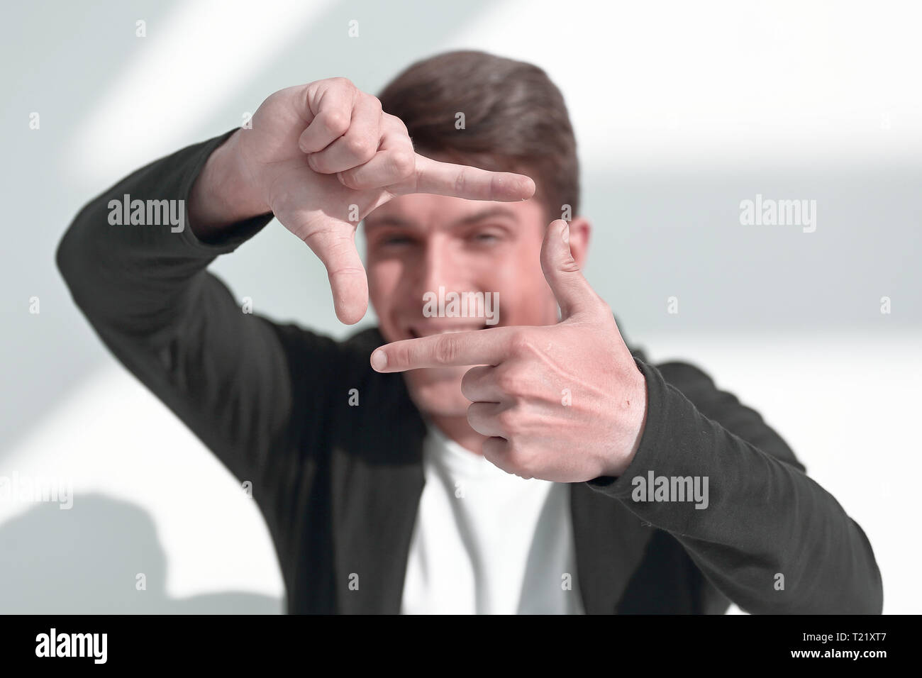 modern guy looks into the frame formed by his hands Stock Photo - Alamy