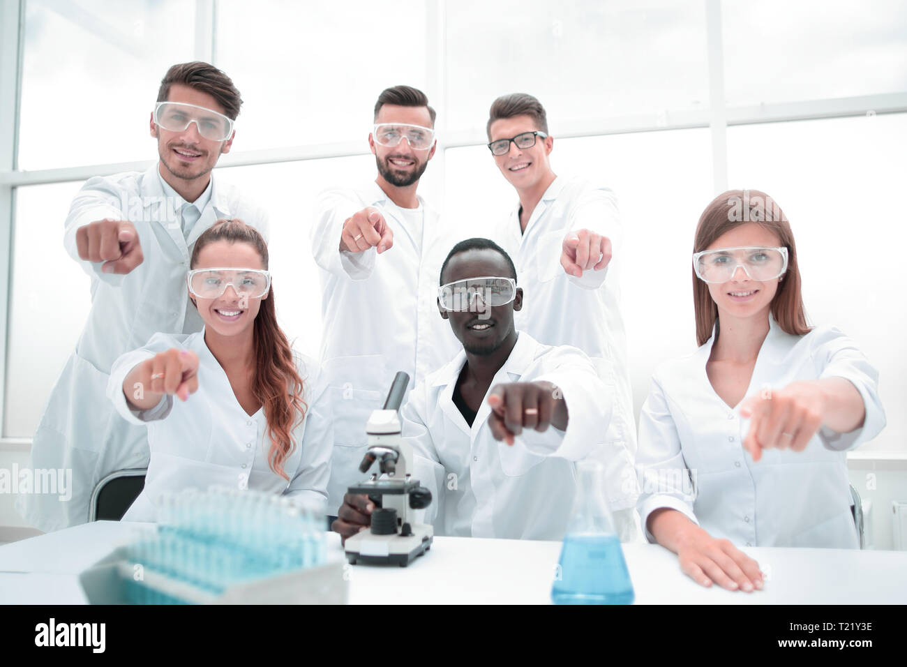 Group of young successful scientists posing for camera Stock Photo - Alamy
