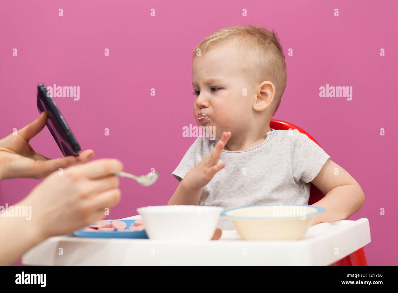 Cute little boy, eats breakfast at home, while watching cartoon on ...