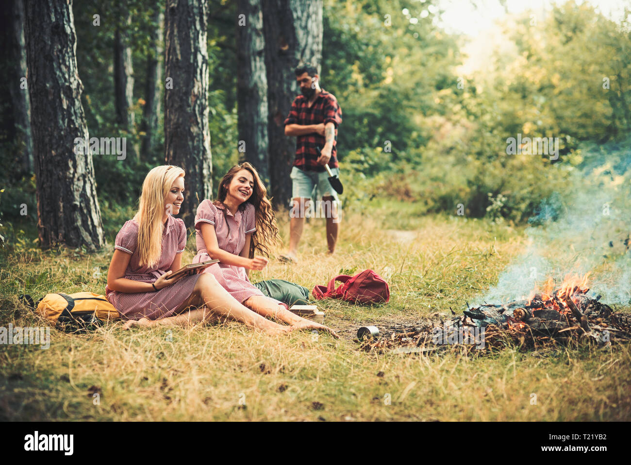 Fashion women in retro dresses relax at bonfire. Happy women with ...