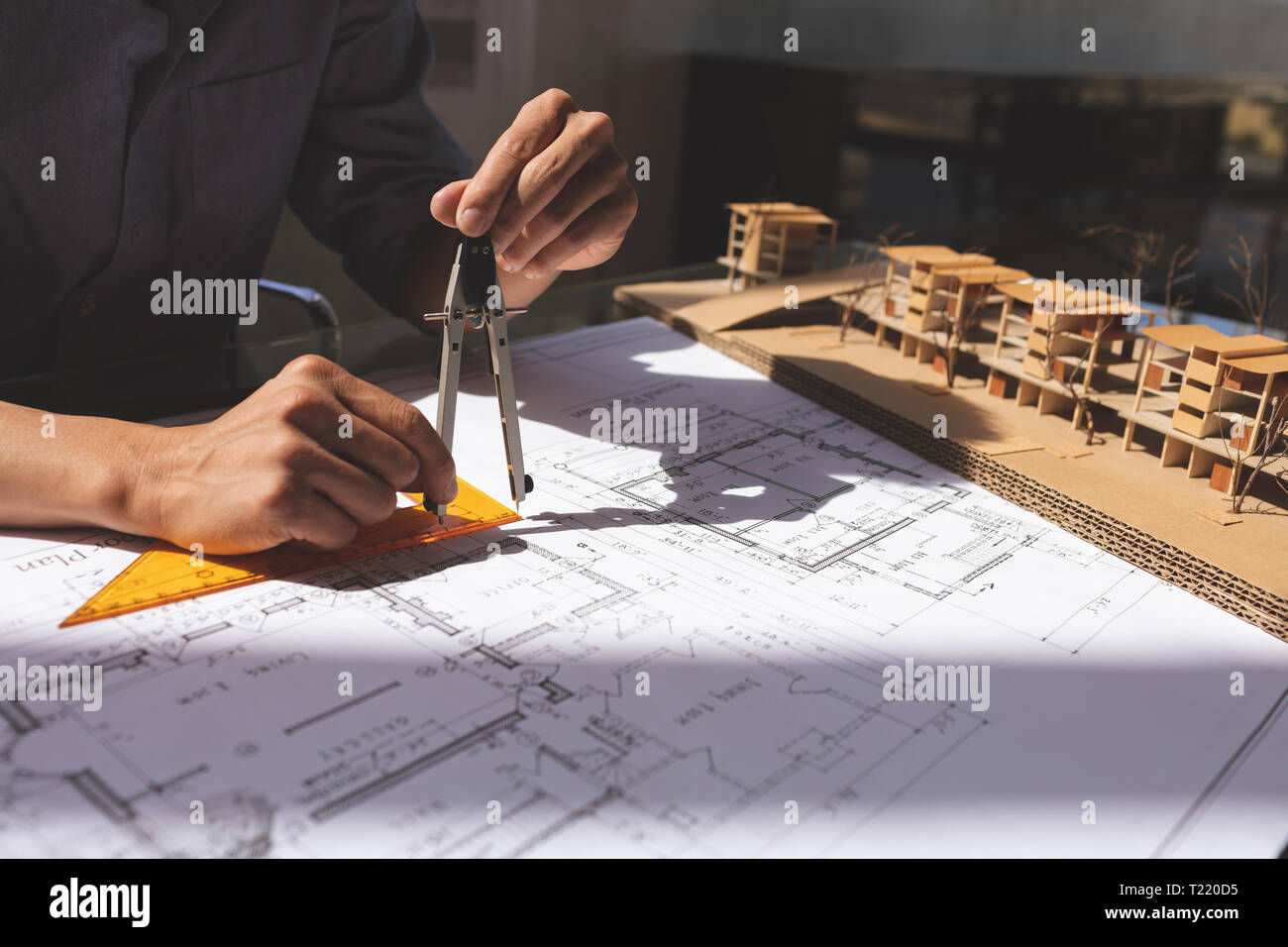 Male architect working on blueprint at desk in a modern office Stock ...