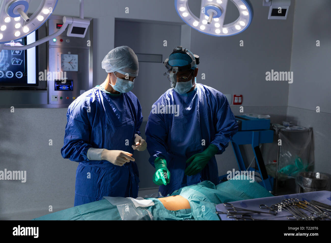 Surgeons performing operation in operating room in hospital Stock Photo ...