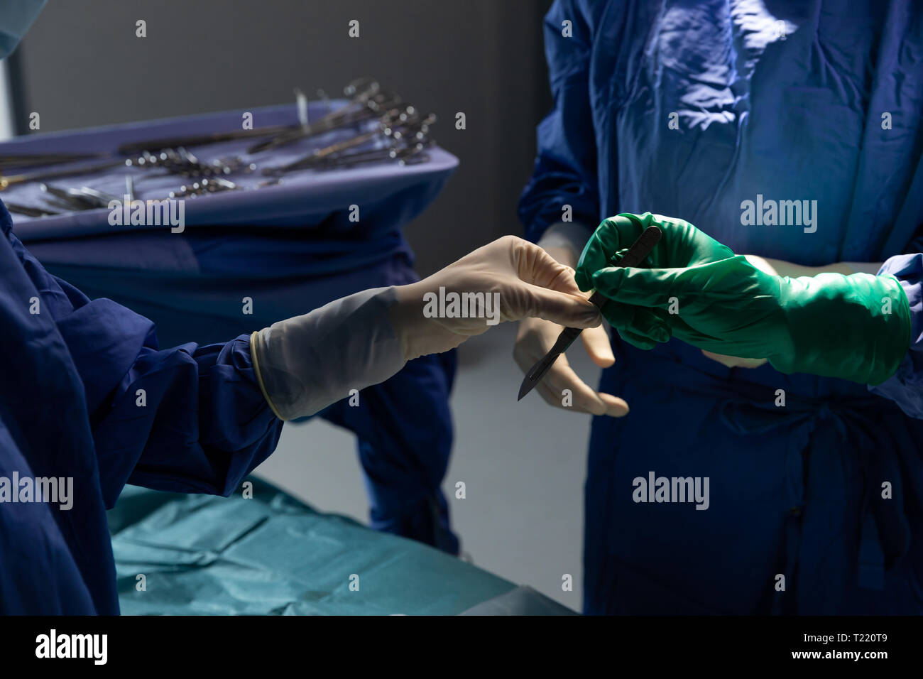 Surgeons holding surgical knife in operating room during surgery Stock ...