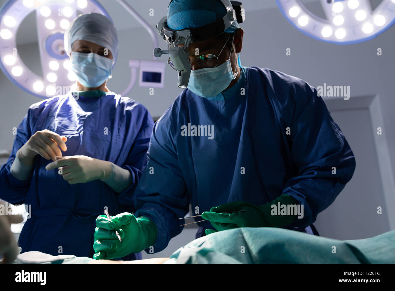 Surgeons performing operation in operating room at hospital Stock Photo ...