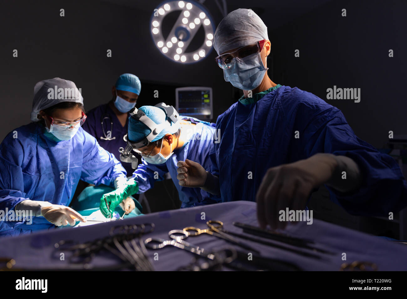 Surgeons performing operation in operating room at hospital Stock Photo ...