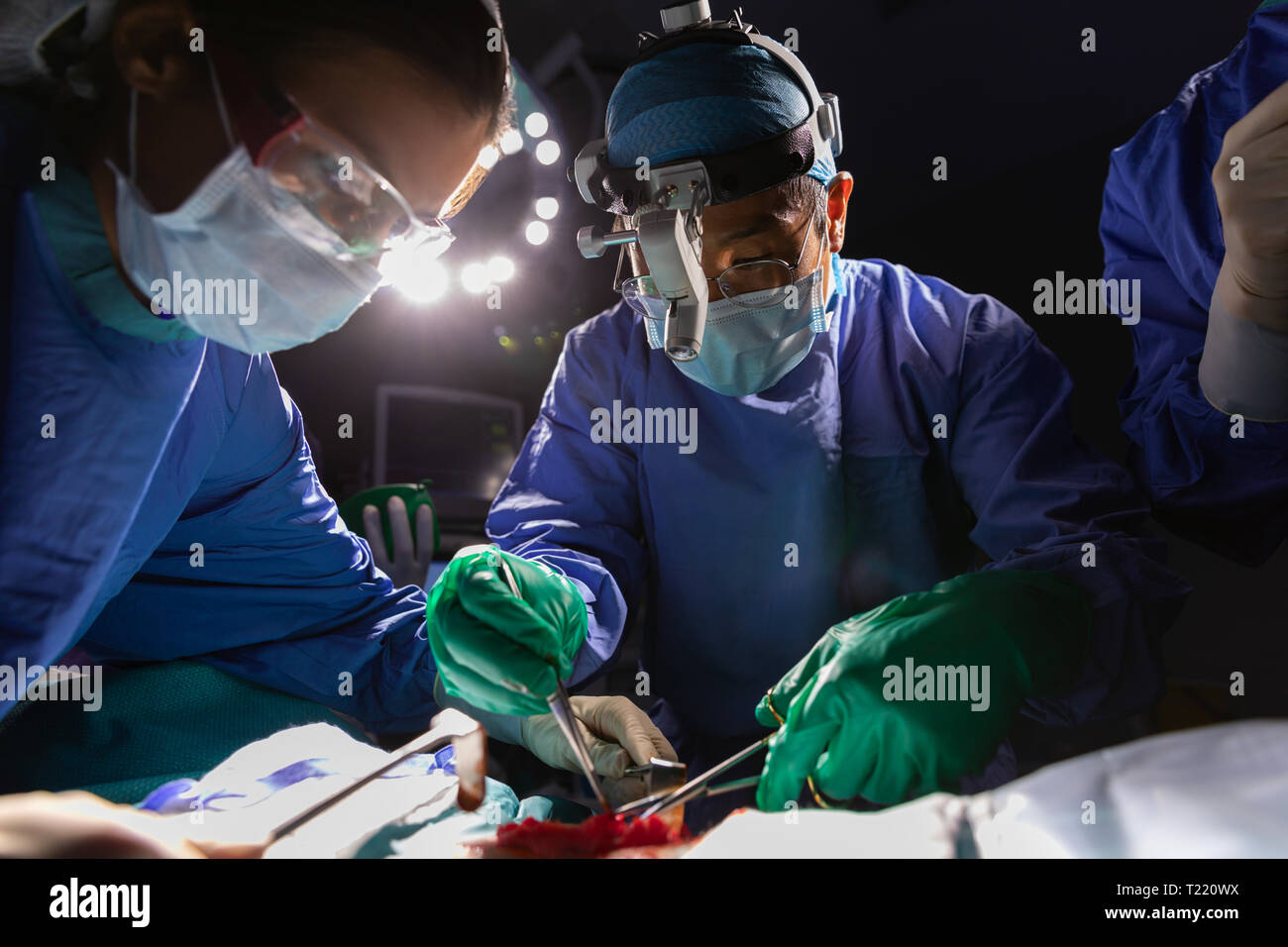 Surgeons performing operation in operating room at hospital Stock Photo ...
