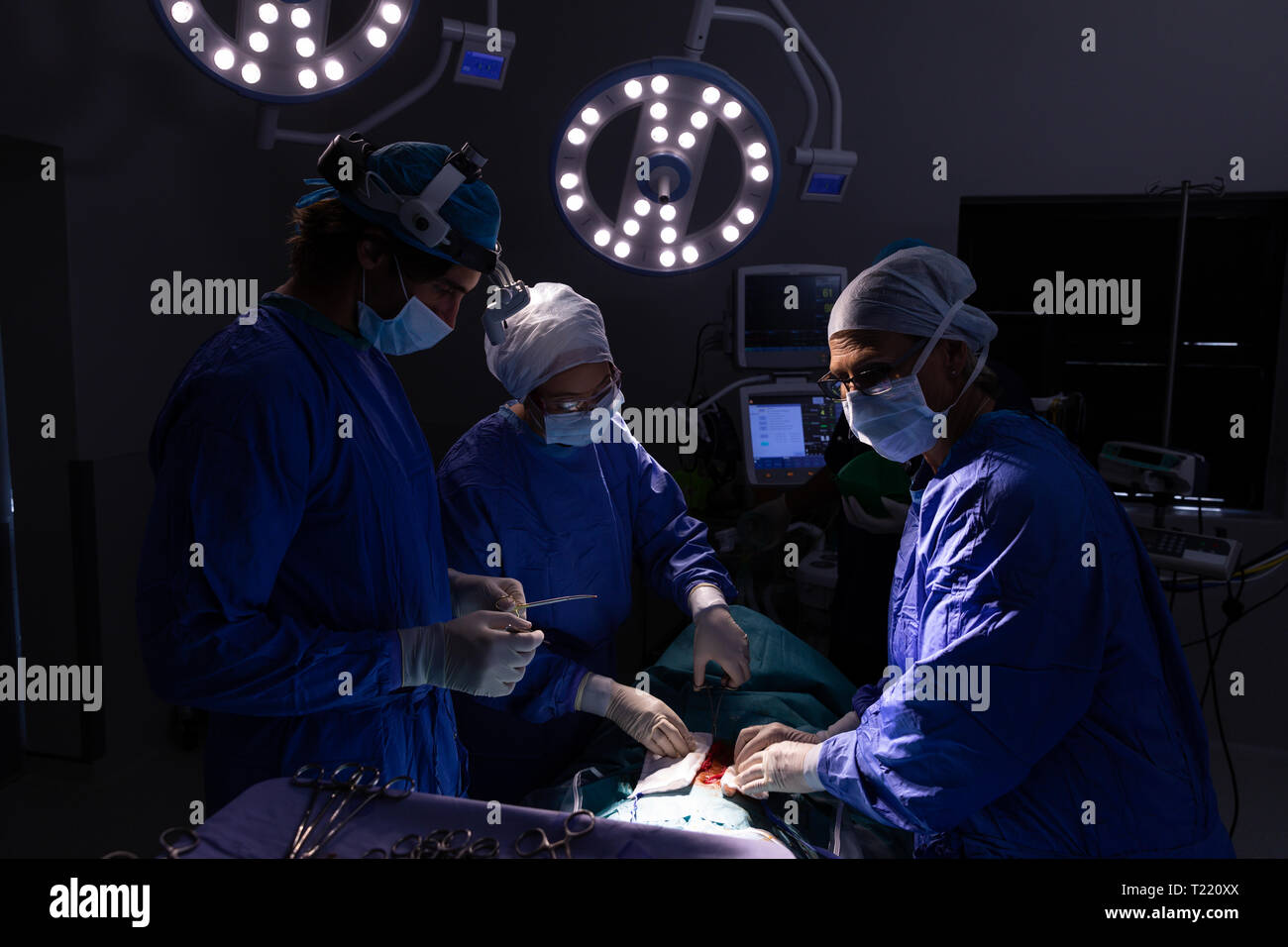 Surgeons performing operation in operating room at hospital Stock Photo ...