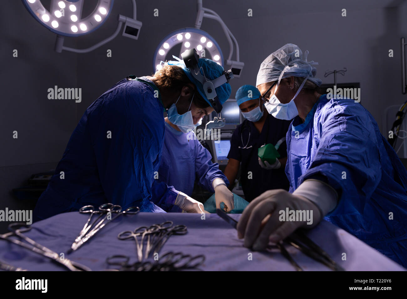 Surgeons performing operation in operating room at hospital Stock Photo ...