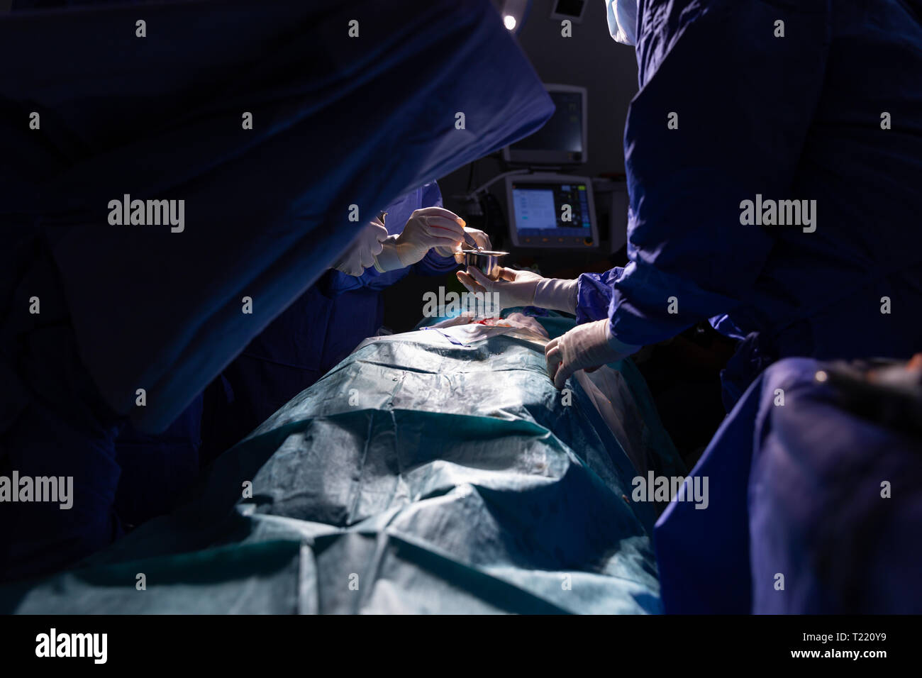 Surgeons performing operation in operating room at hospital Stock Photo ...