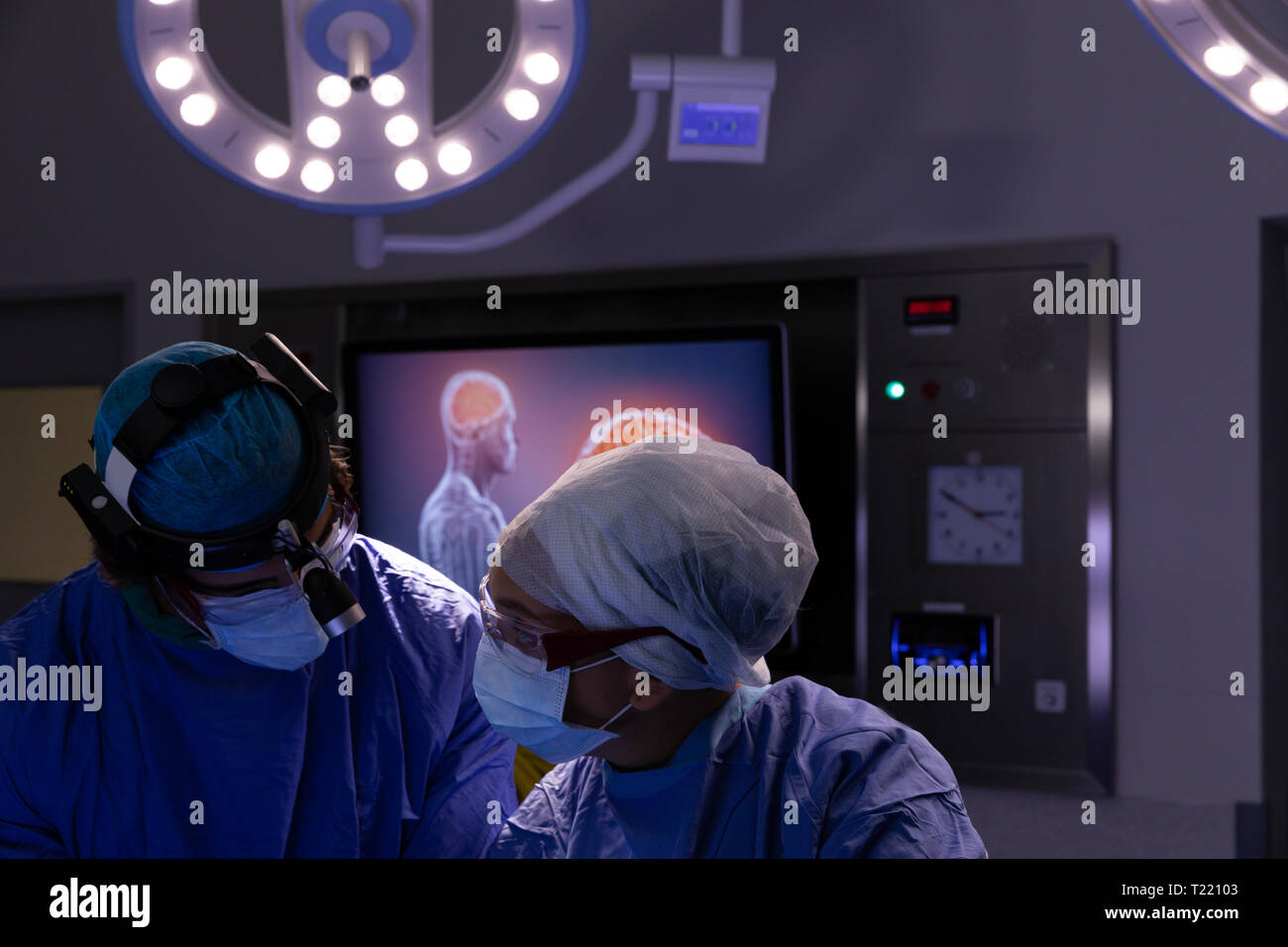 Surgeons talking with each other during surgery in operating room at ...