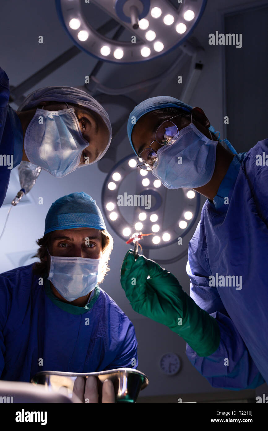 Surgeons performing operation in operating room at hospital Stock Photo ...