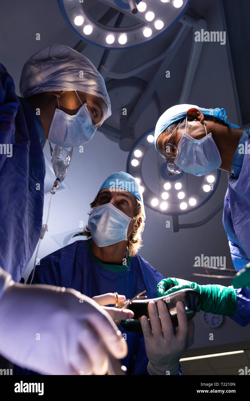Surgeons performing operation in operating room at hospital Stock Photo ...