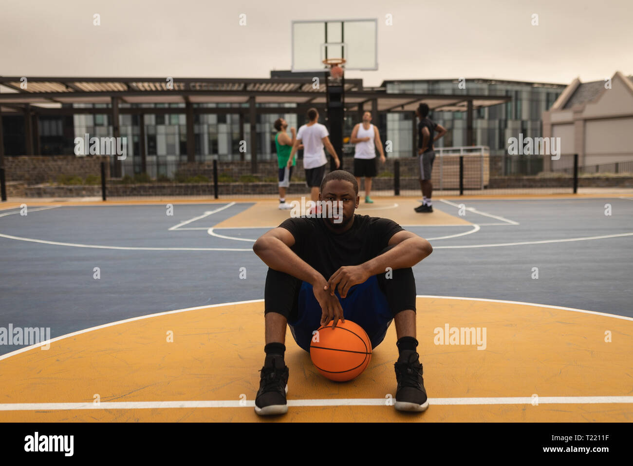 Confident player relaxing on basketball over basketball court Stock ...