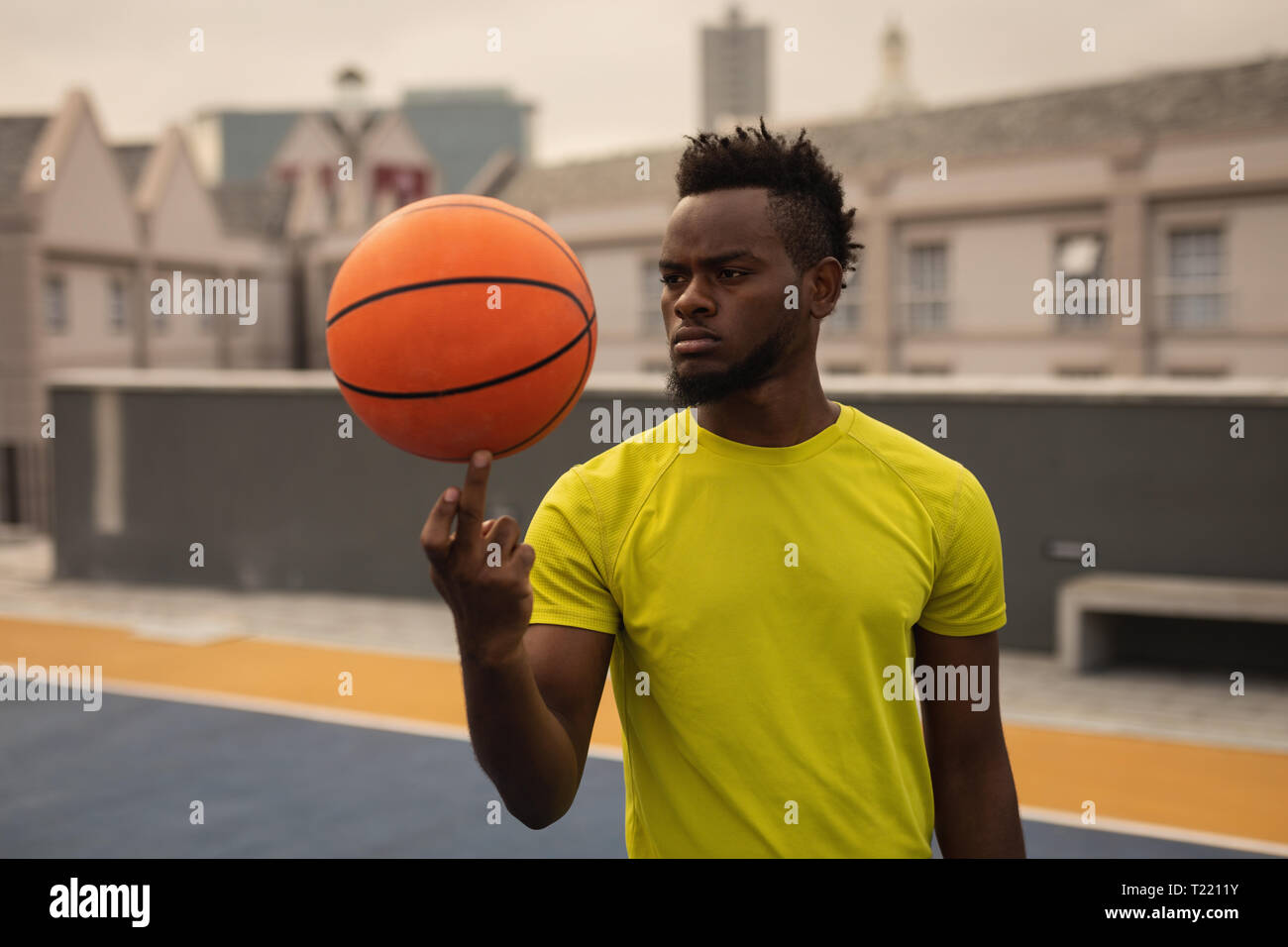 Basketball player balancing ball on finger at basketball court Stock ...