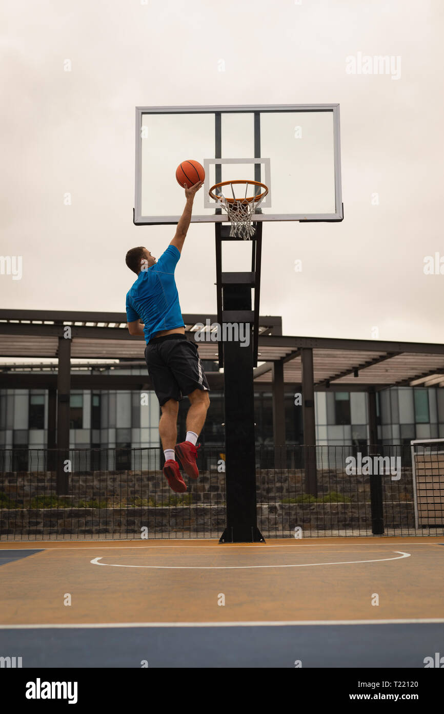 Basketball player scoring a hoop on a basketball court Stock Photo - Alamy