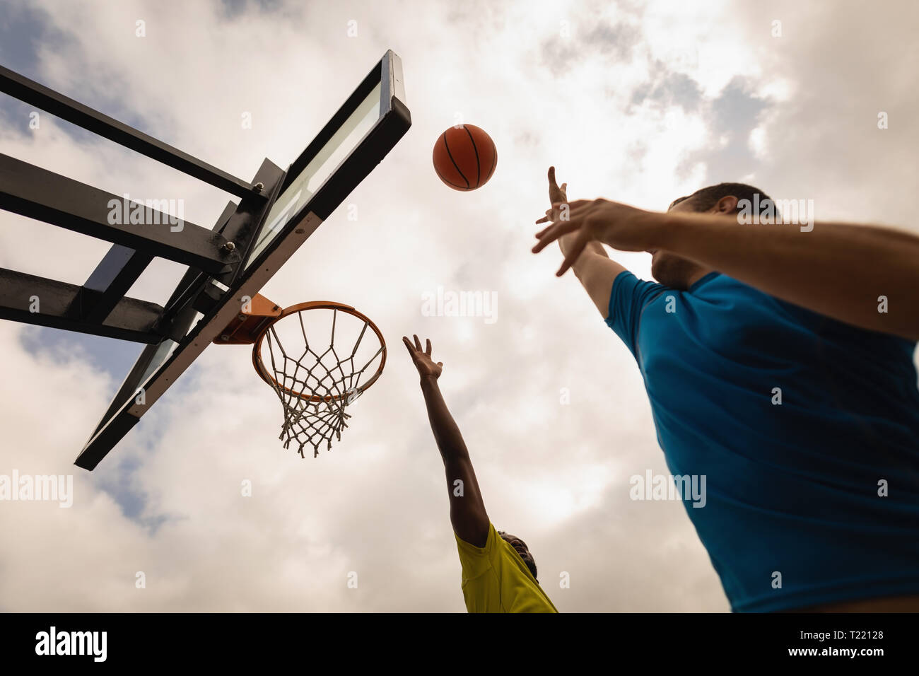 Players playing basketball at basketball court Stock Photo - Alamy