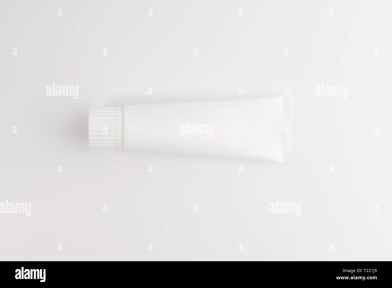 Blank white tube of toothpaste, cream or gel standing on white ...