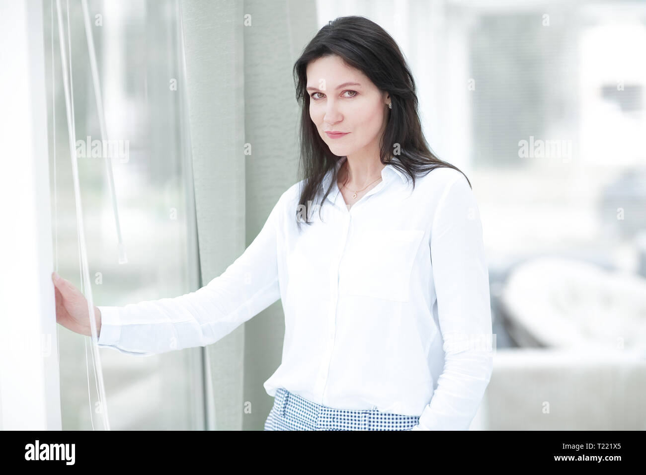 closeup.serious business woman standing near the window in the office ...