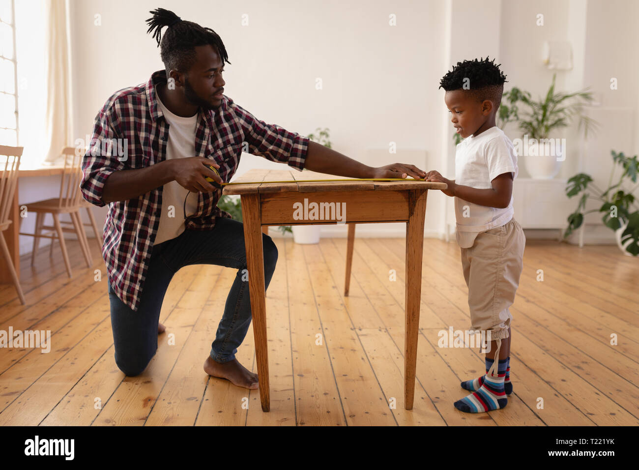 Father and son measuring table with measurement tape Stock Photo - Alamy