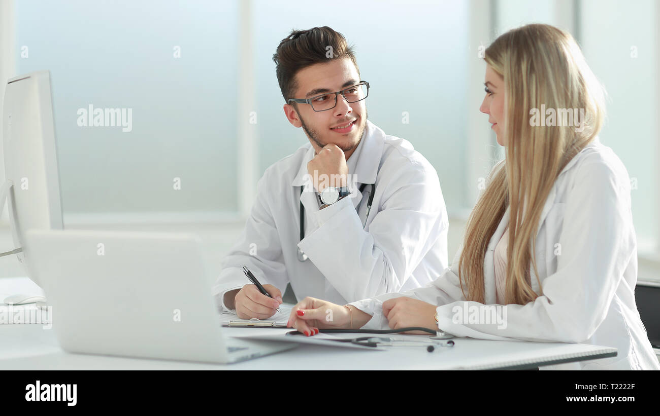 doctors colleagues talking sitting at a table in the office.photo with ...