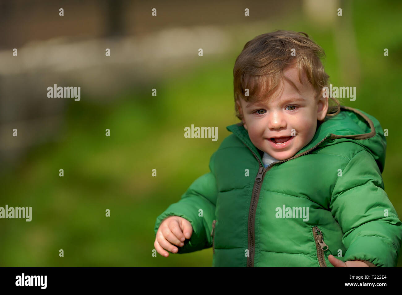 Happy baby with coat and hat in cold sunny weather Stock Photo - Alamy