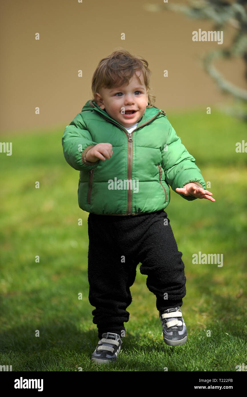 Happy baby with coat and hat in cold sunny weather Stock Photo - Alamy
