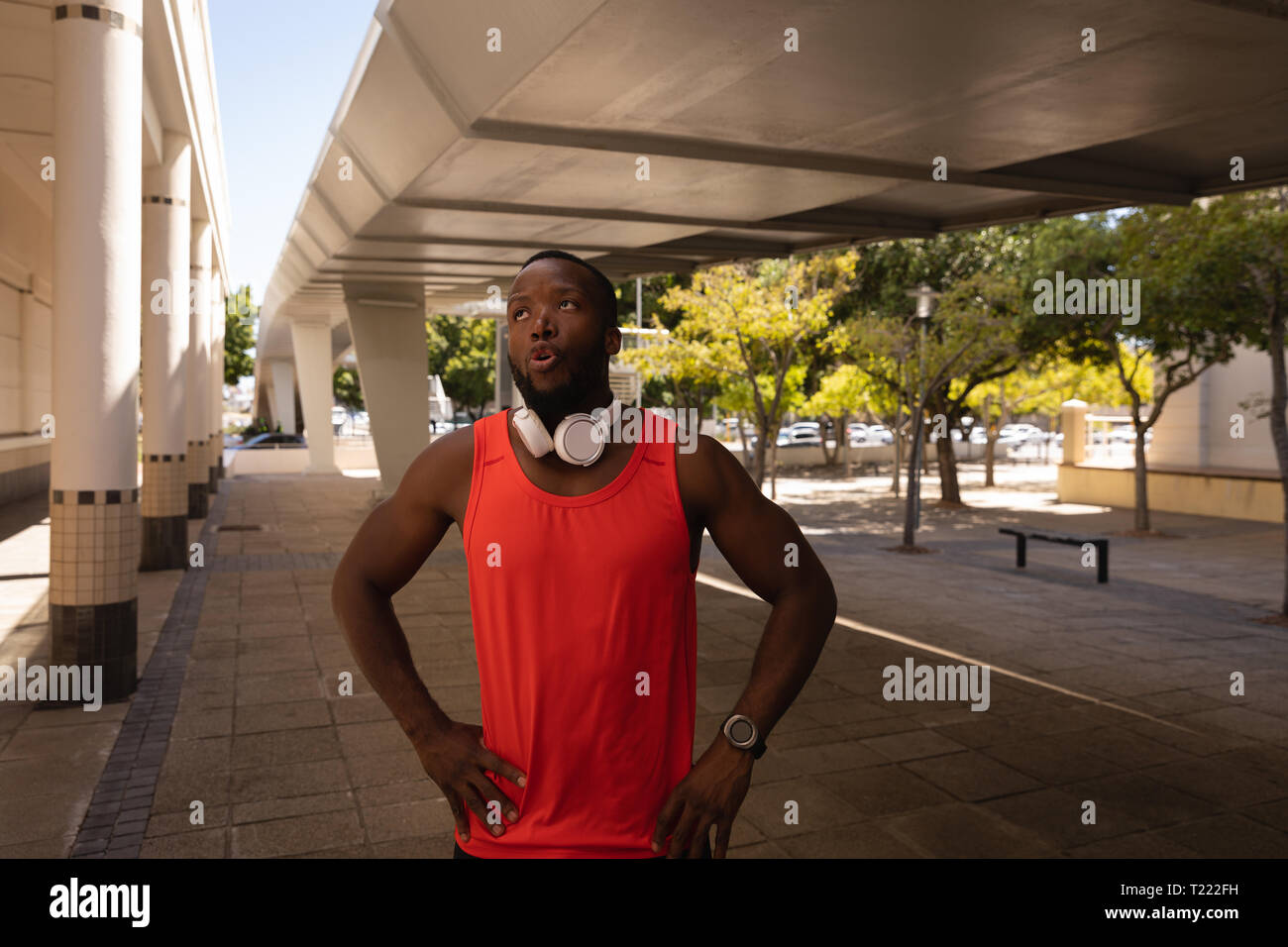 Man with headset standing on pavement under the bridge Stock Photo - Alamy